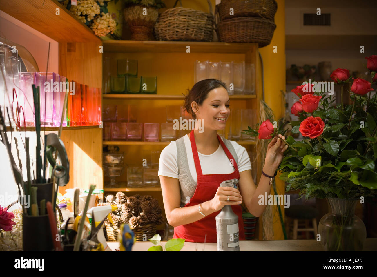 Young woman in flower shop with rose arrangement Stock Photo - Alamy