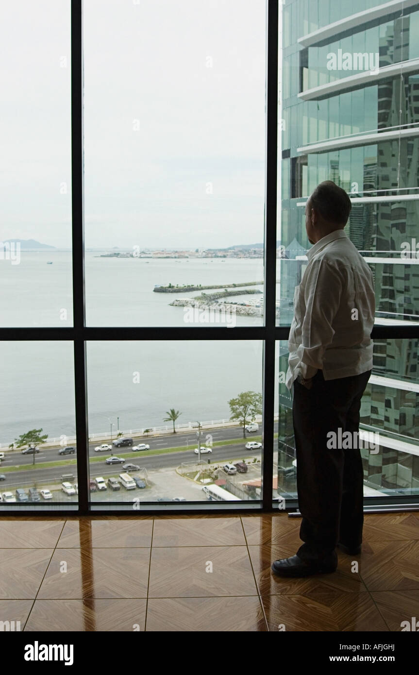 Businessman looking out office window Stock Photo - Alamy