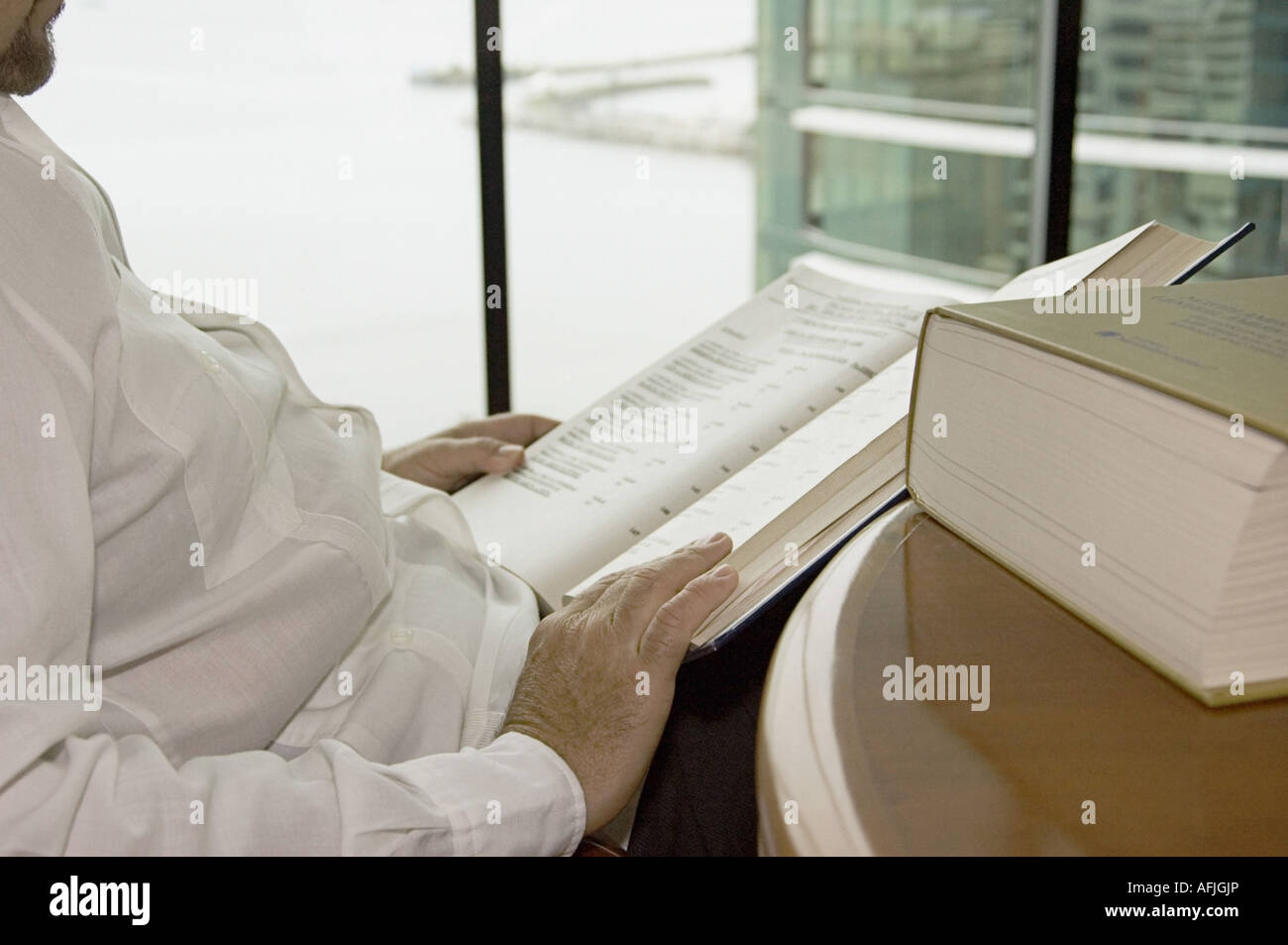 Businessman reading book in office Stock Photo - Alamy
