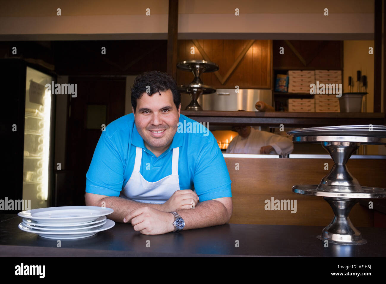 Portrait of chef behind restaurant counter Stock Photo - Alamy