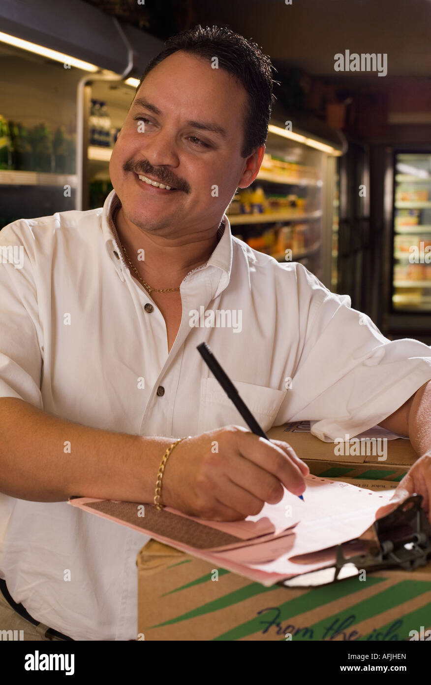 Small businessman taking inventory of groceries Stock Photo - Alamy