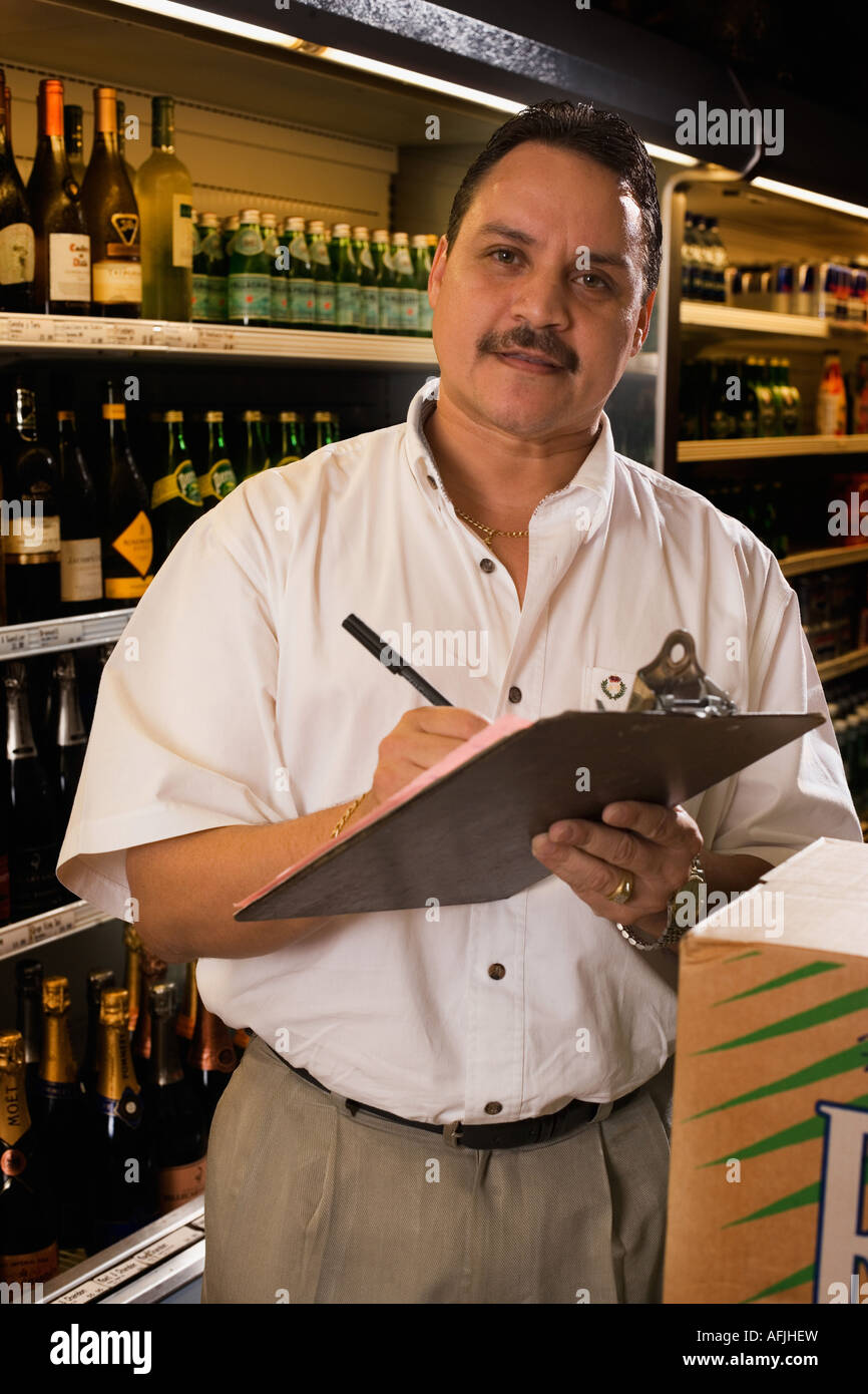 Small businessman taking inventory of groceries Stock Photo - Alamy