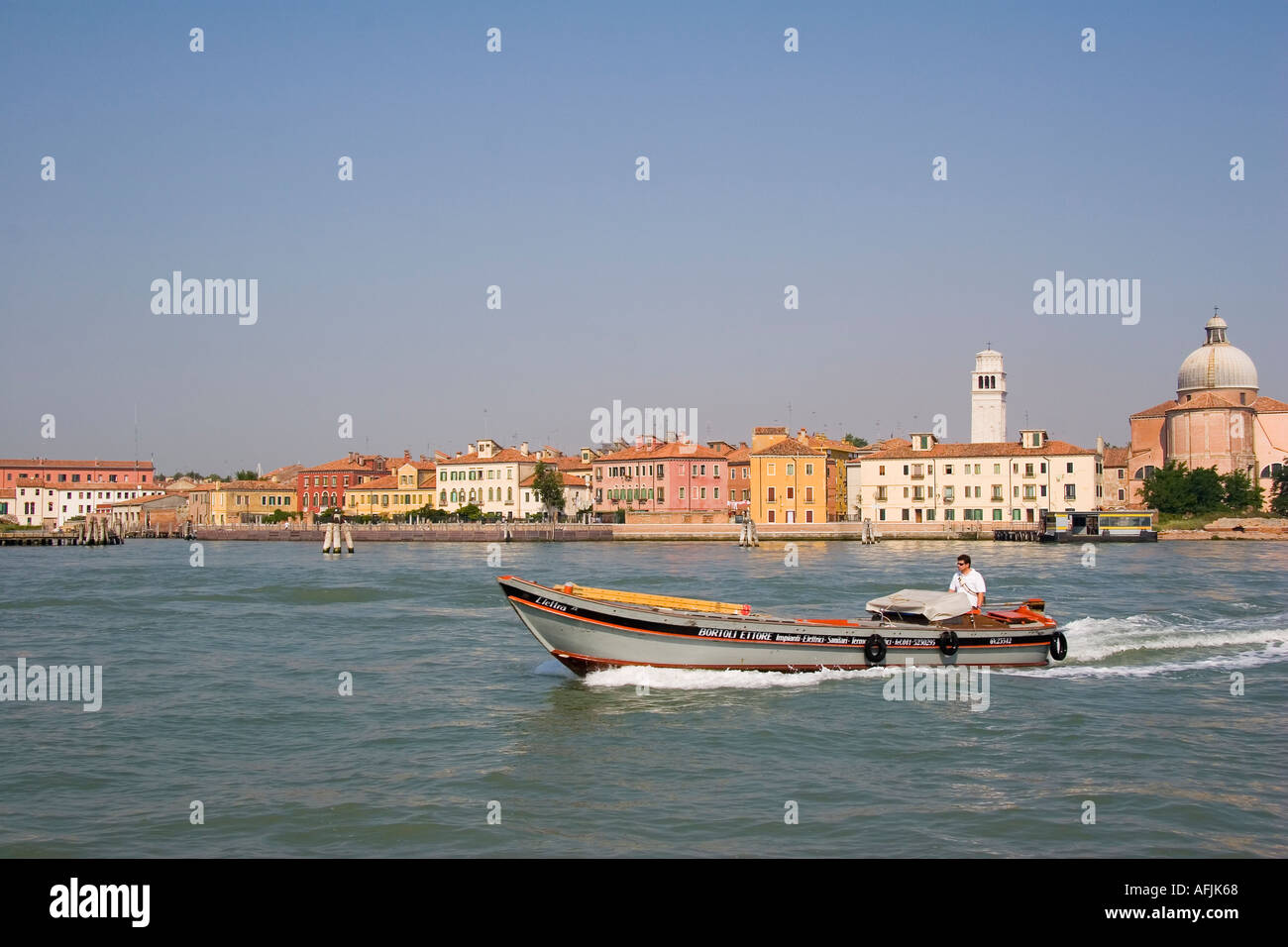 Man pilots work boat past Isola di S Pietro island Venice Italy Stock ...