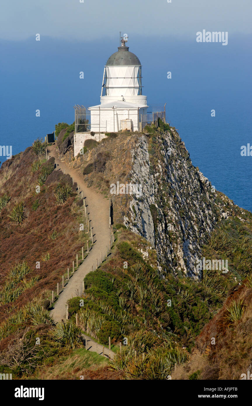 An isolated lighthouse perched upon a rocky outcrop above the sea, with ...