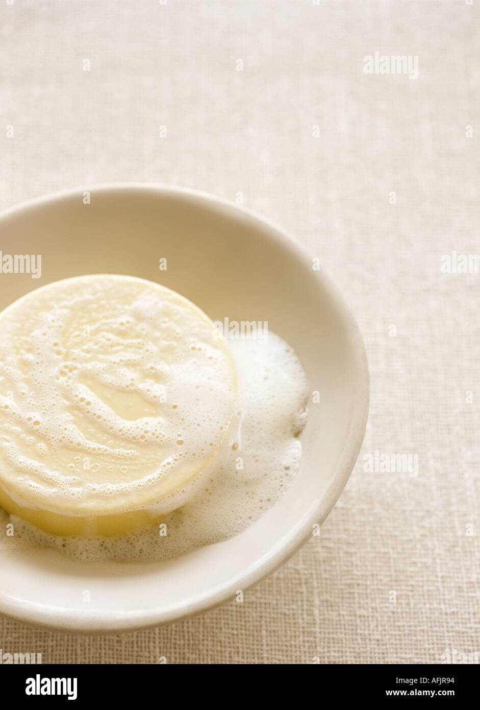 Soap with lather in soapstone dish on pale linen background Stock Photo ...