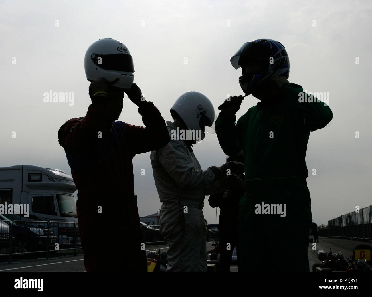 kart drivers put on their helmets on the start finish grid in ...