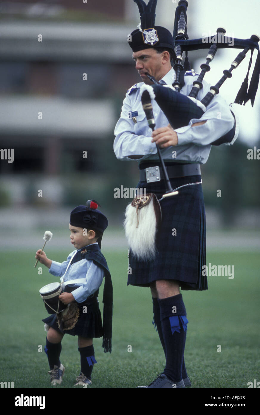 USA Alaska Anchorage MR Rick Ford plays bagpipes with son Kegan wearing ...
