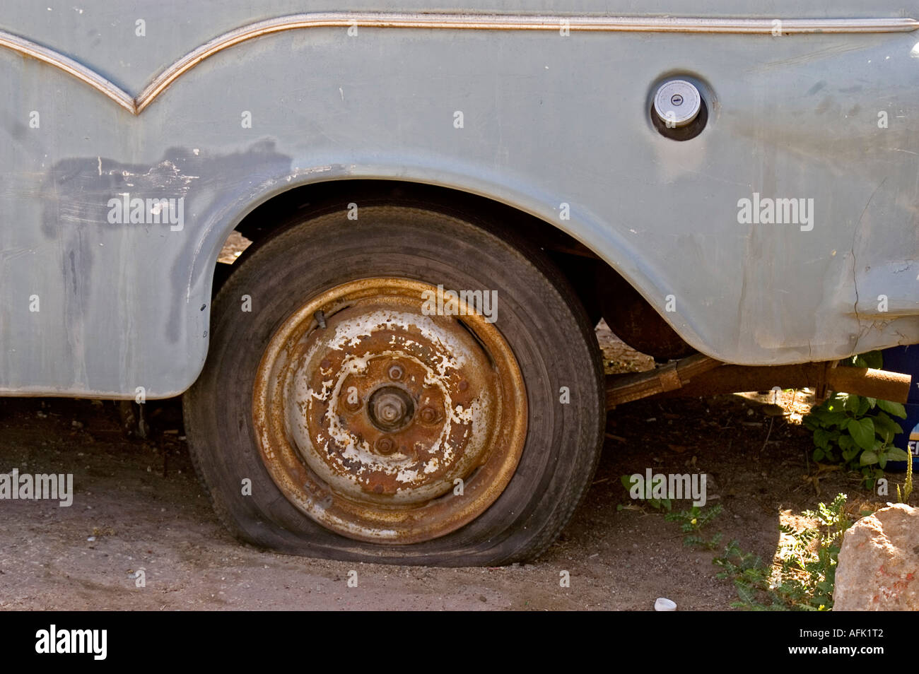 Old dilapidated car with a flat tire Stock Photo - Alamy