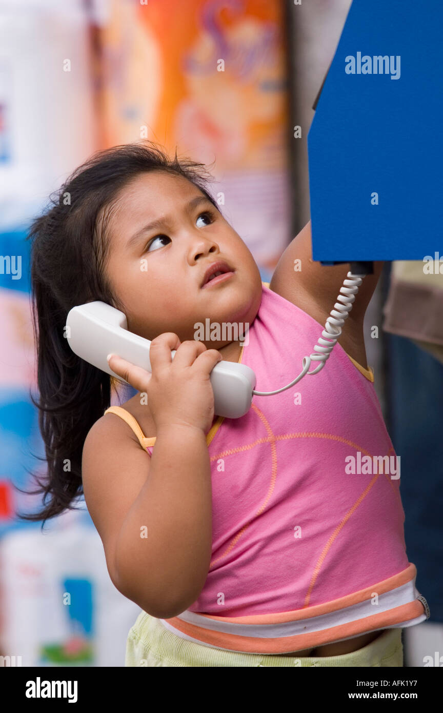 Young girl reaching to the phone to make a call Stock Photo - Alamy