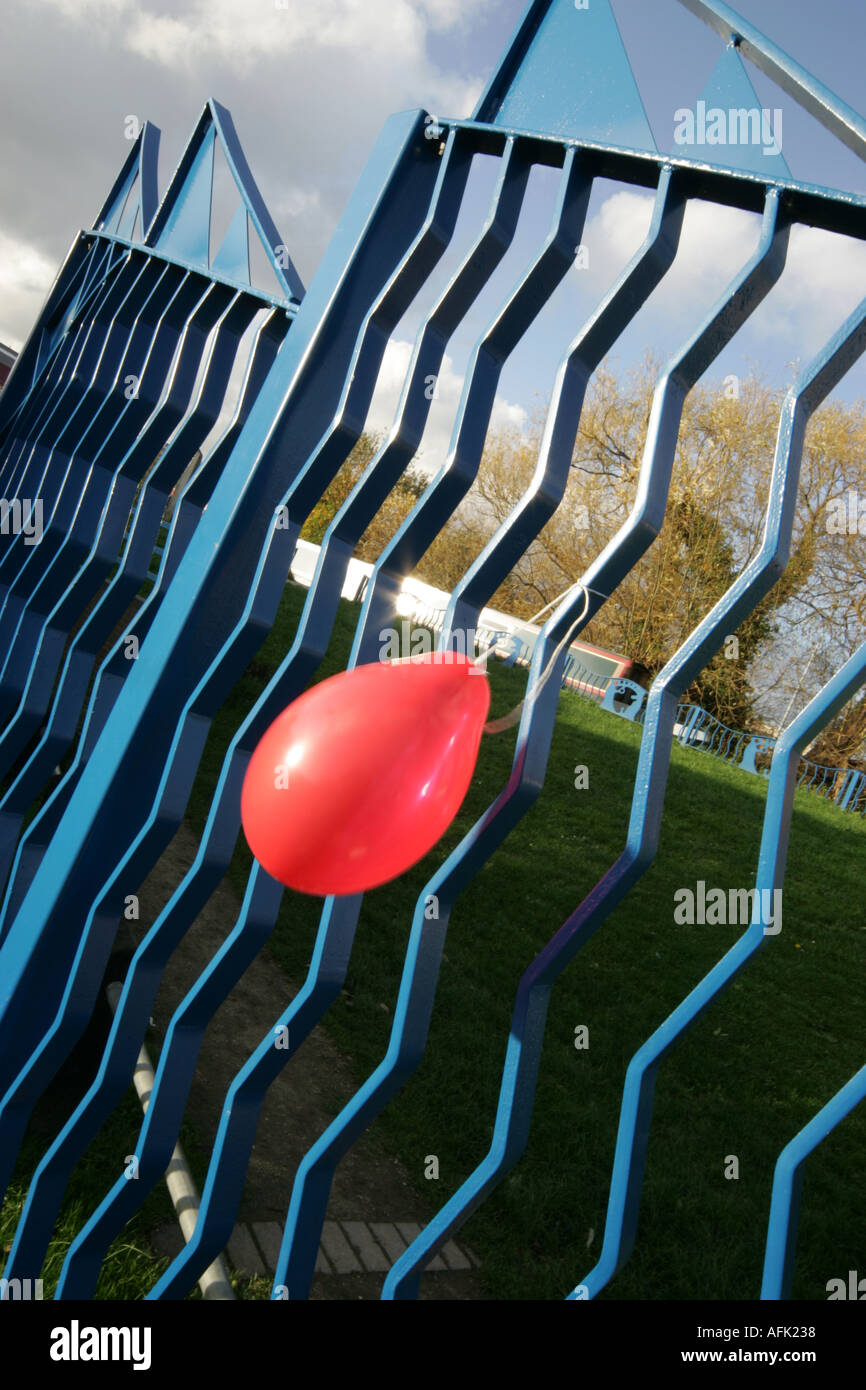Red balloon tied to a blue fence Stock Photo - Alamy