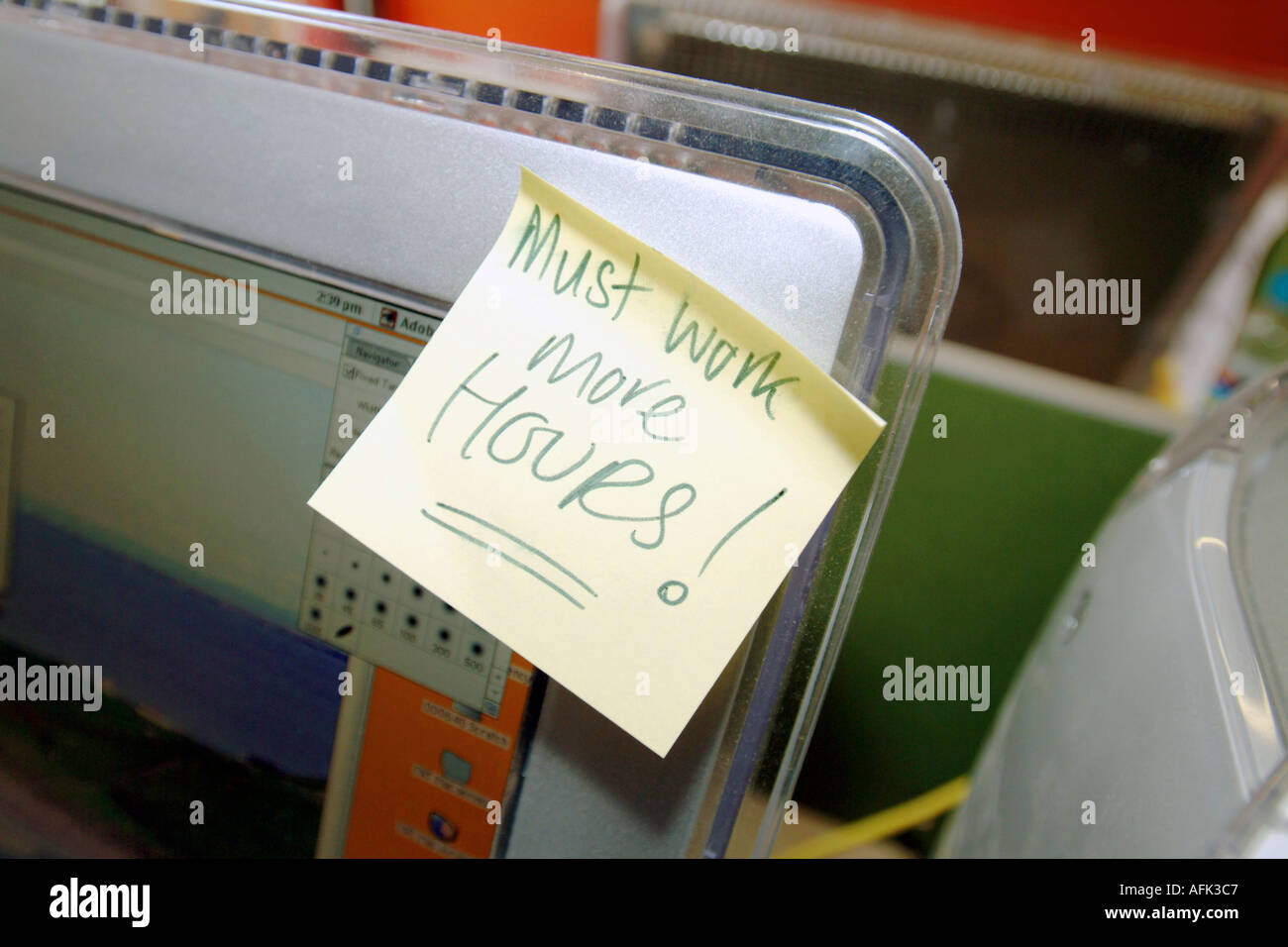 A computer workstation desk with a post it reminder Stock Photo - Alamy