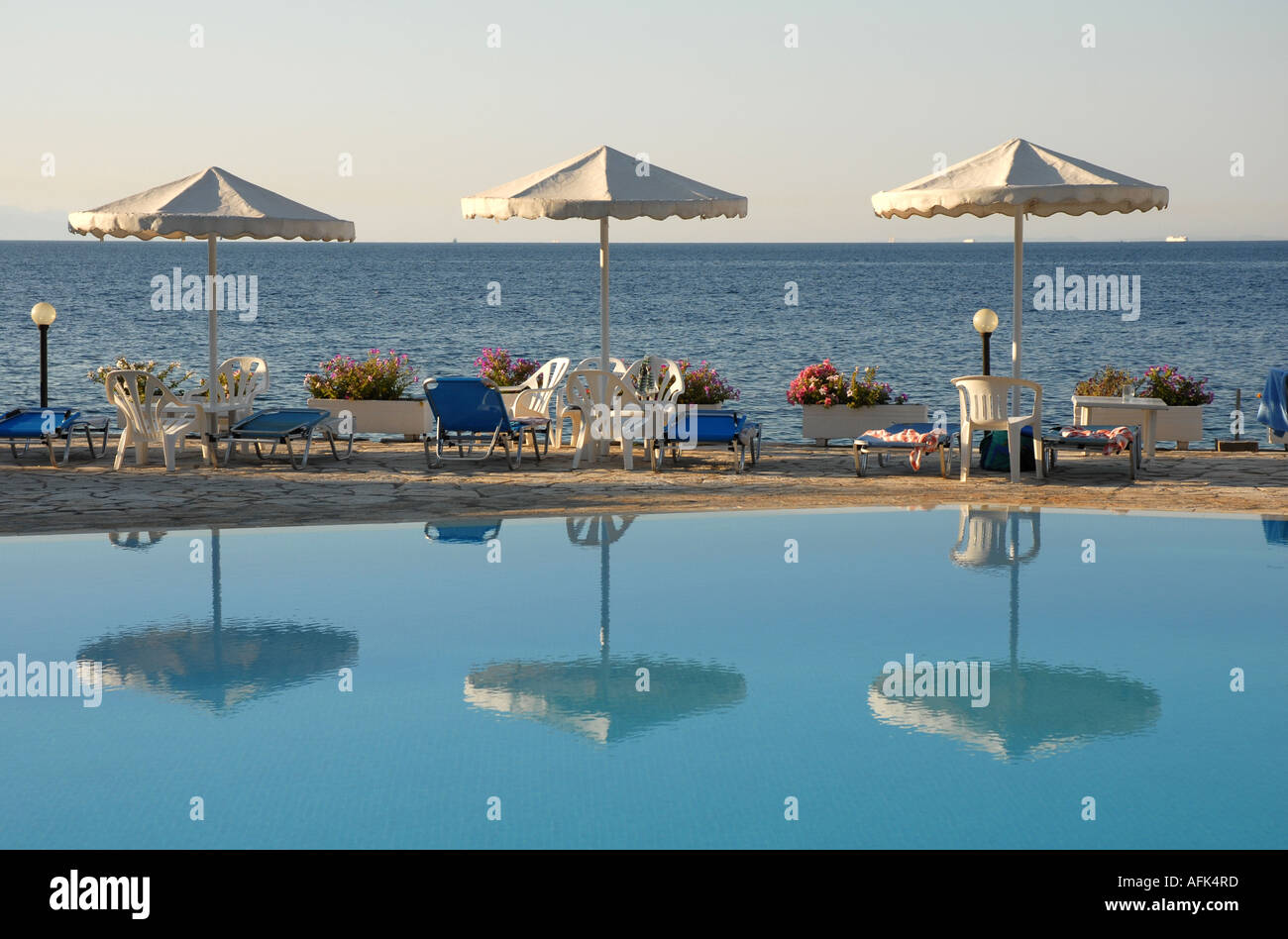 Swimming pool in early morning with water dead calm. Reflections of ...