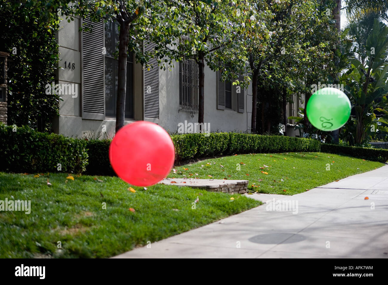 Two balloons flying over a walkway Stock Photo - Alamy