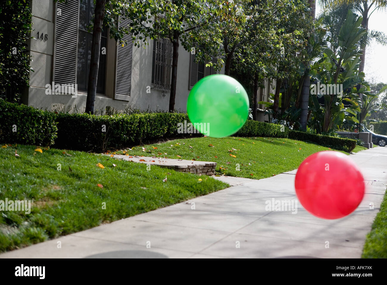 Two balloons flying over a walkway Stock Photo - Alamy