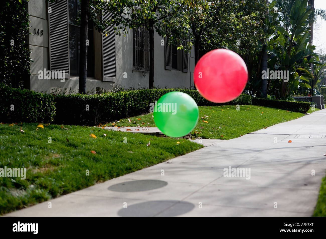 Two balloons flying over a walkway Stock Photo - Alamy
