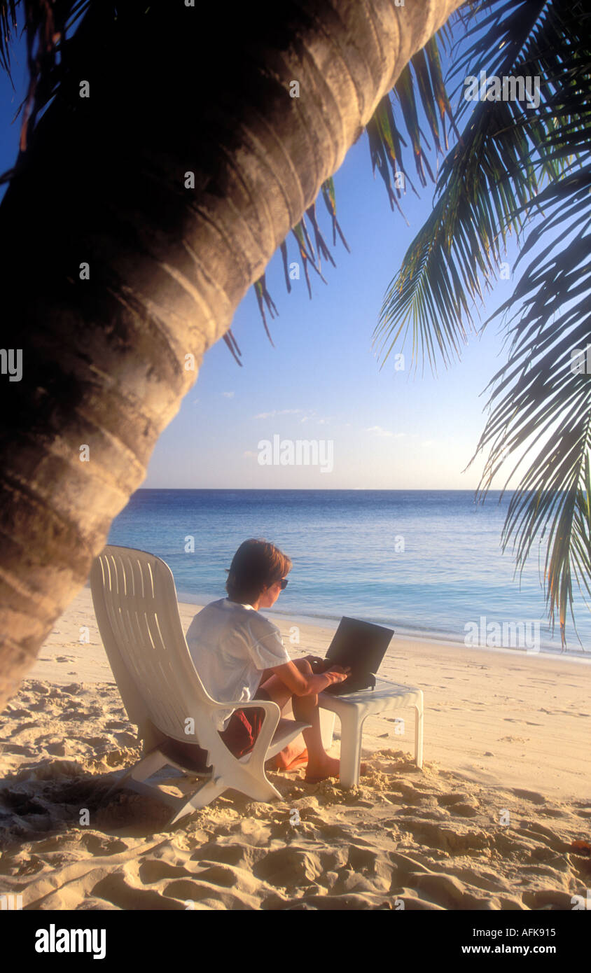 Woman working on laptop computer on beach Model Released Image Stock ...