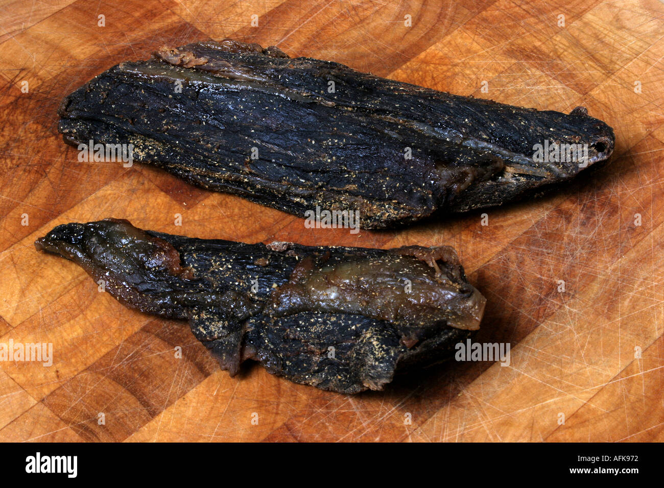 Biltong South African dried meat on a wooden chopping block Stock Photo ...