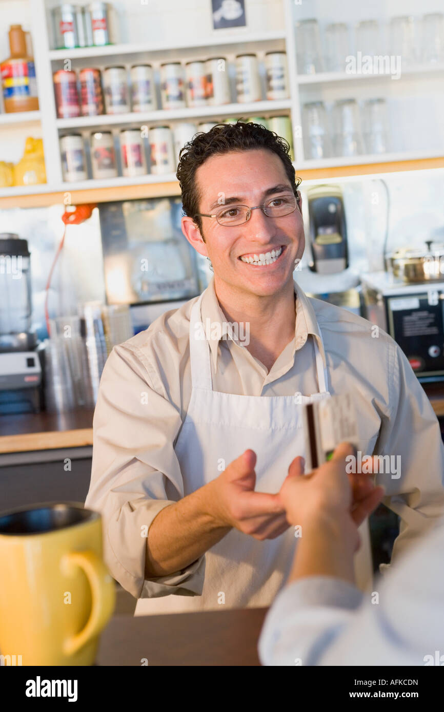 Person's hand giving a credit card to a male store clerk Stock Photo ...