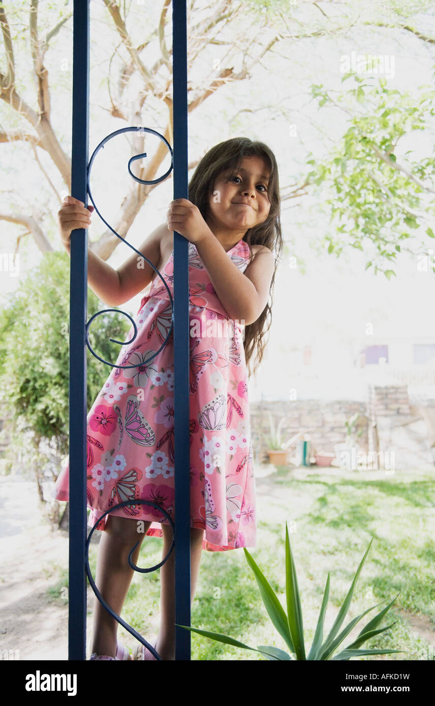 Young girl climbing railing Stock Photo - Alamy