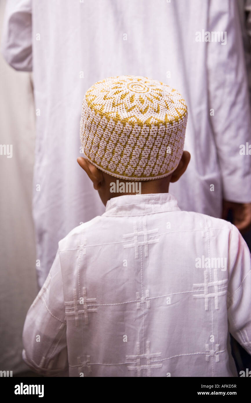 A boy follows his father through the crowds outside the Sayyida Ruqayya ...