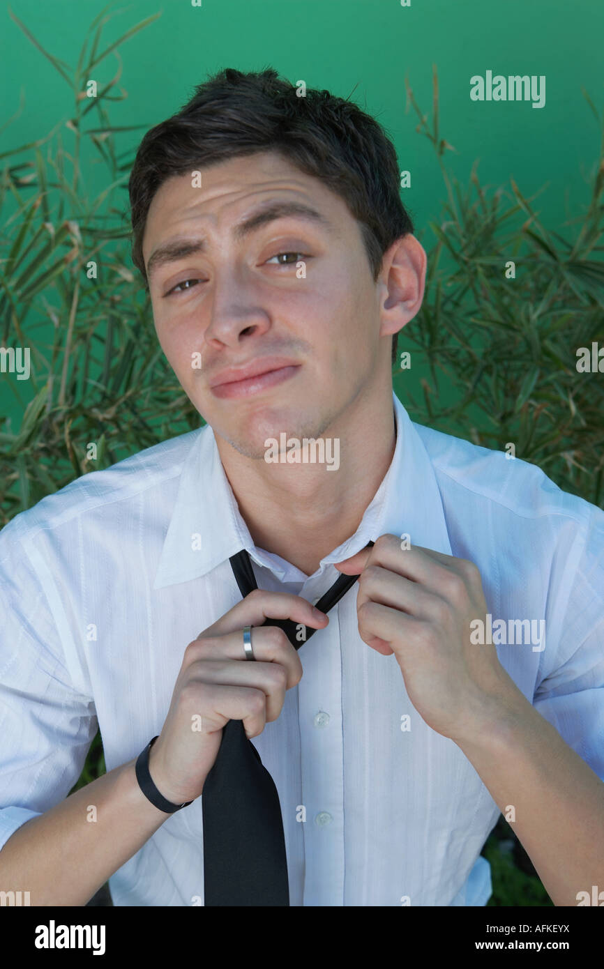 Young man fixing his tie Stock Photo - Alamy