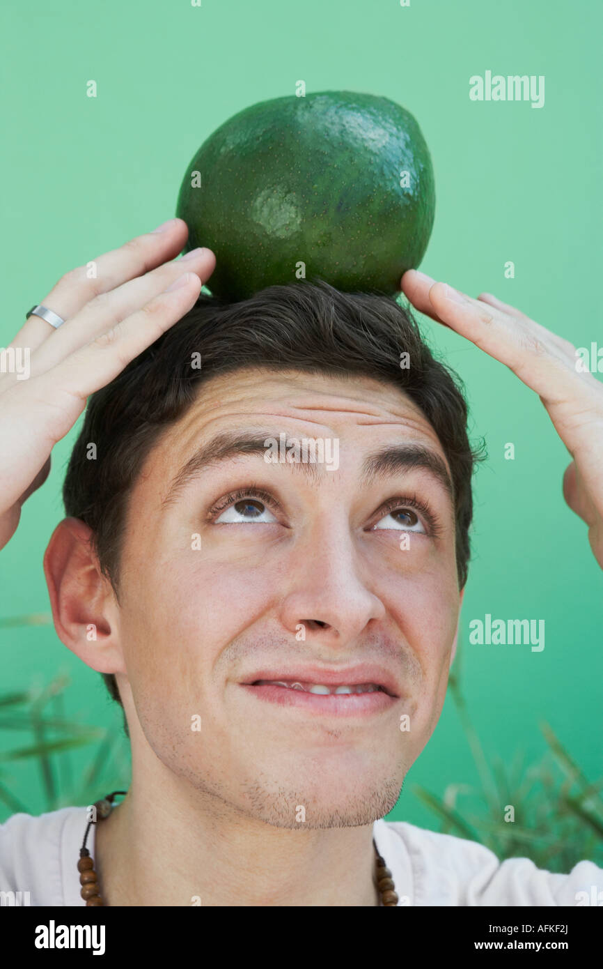 Young man balancing an avocado on his head Stock Photo - Alamy