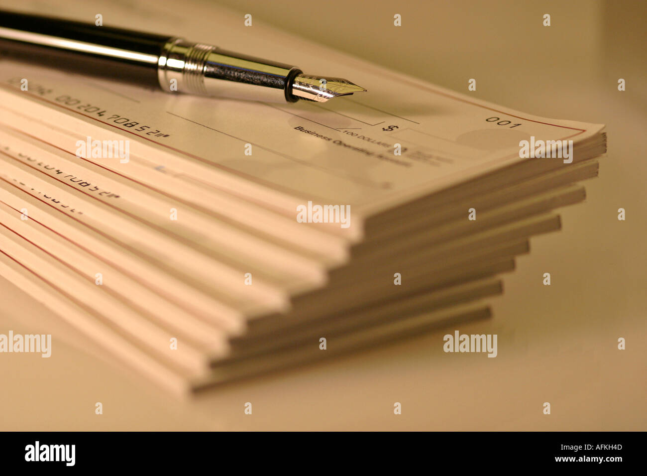 Fountain pen on business cheque book stack Stock Photo - Alamy
