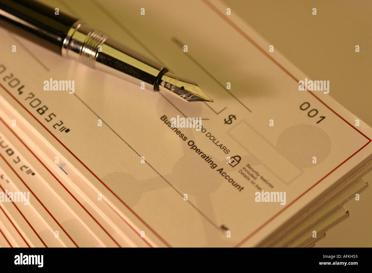 Fountain pen on business cheque book stack Stock Photo - Alamy