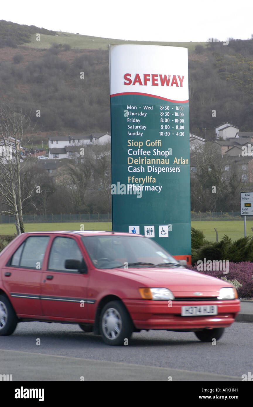 smal red car driving past Bilingual welsh english signs Safeway ...