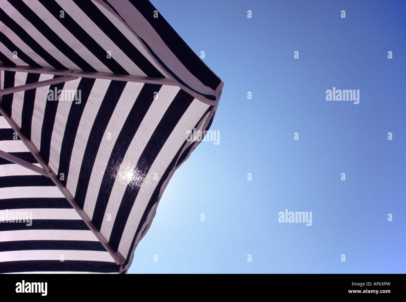 striped sun shade in sun and blue sky Stock Photo - Alamy