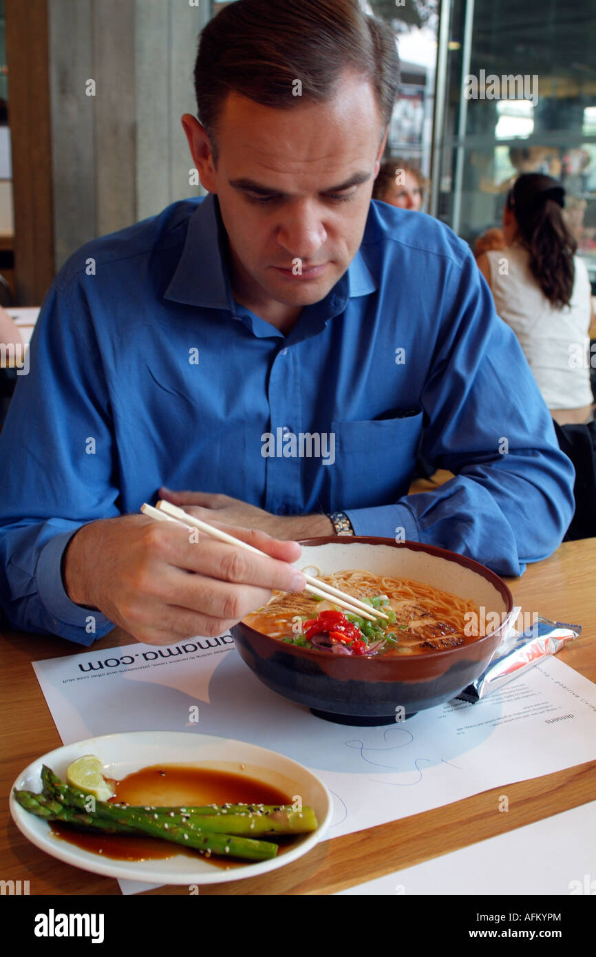 Man Eating Meal in a Restaurant Pan Asian Food Dish Eating noodles ...