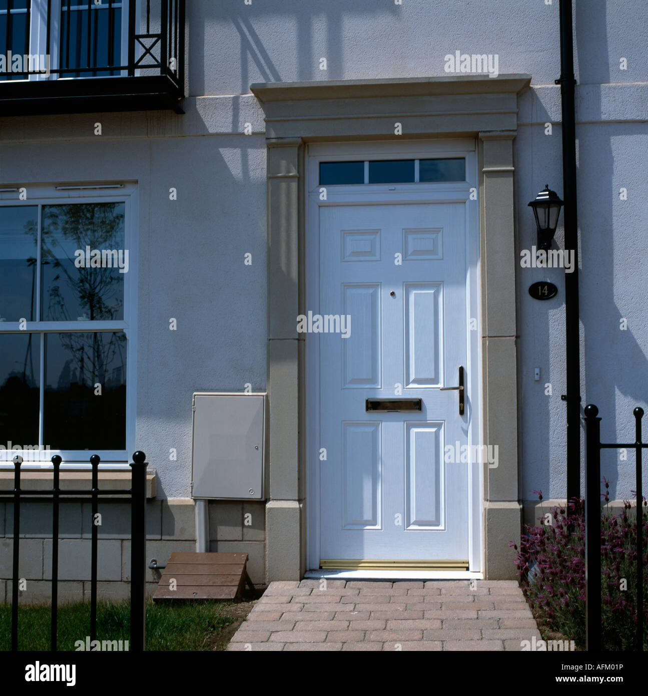 White front door in traditional town house with concealed gas meter on ...