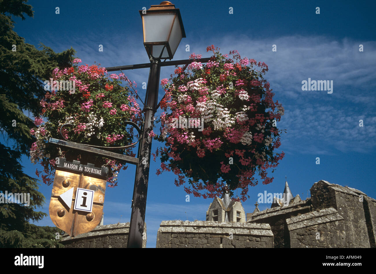 Tourist office signpost and hanging flower baskets on lamp post with ...