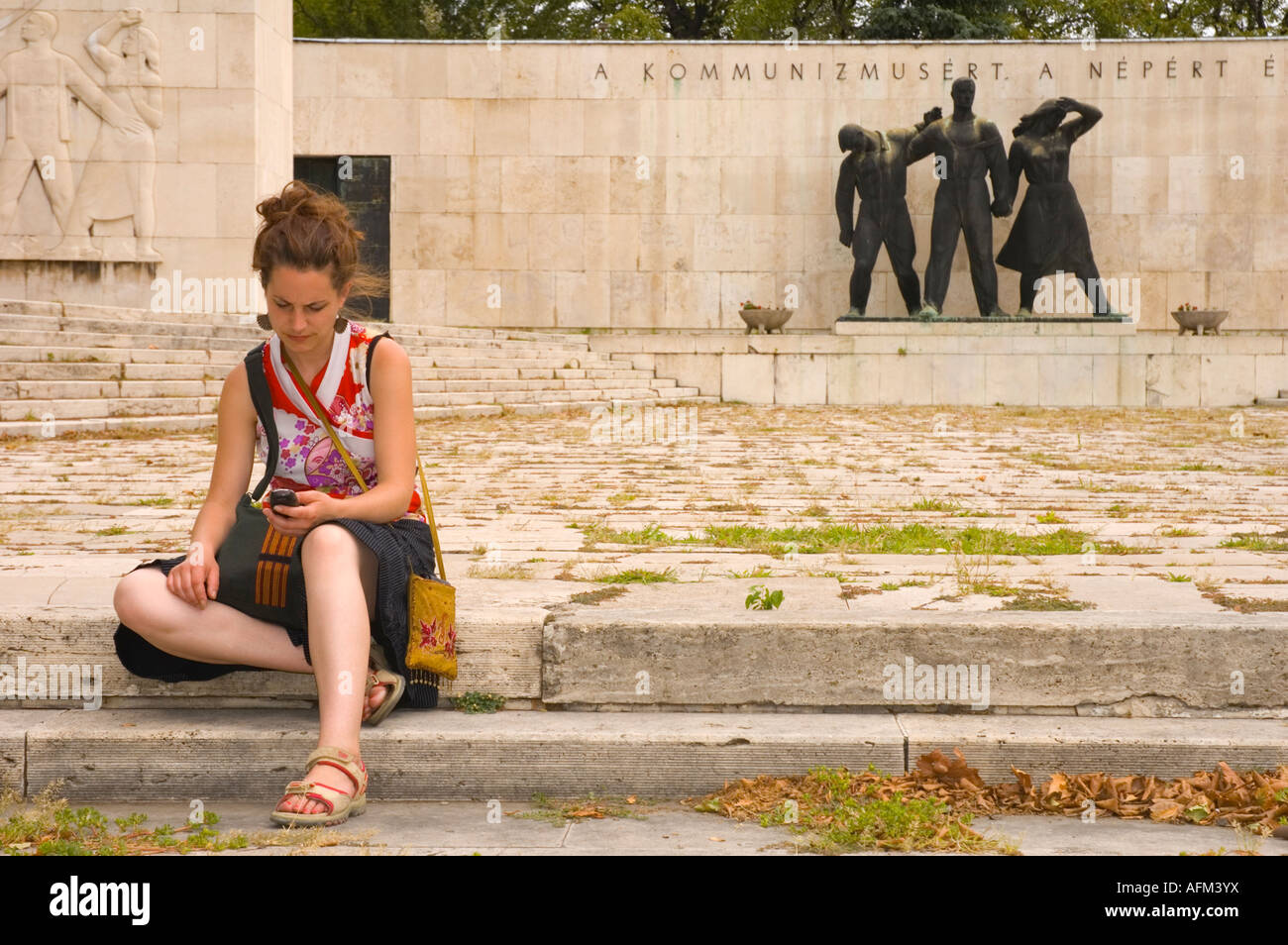 Girl writing an sms at Pantheon of the Working Class Movement monument ...