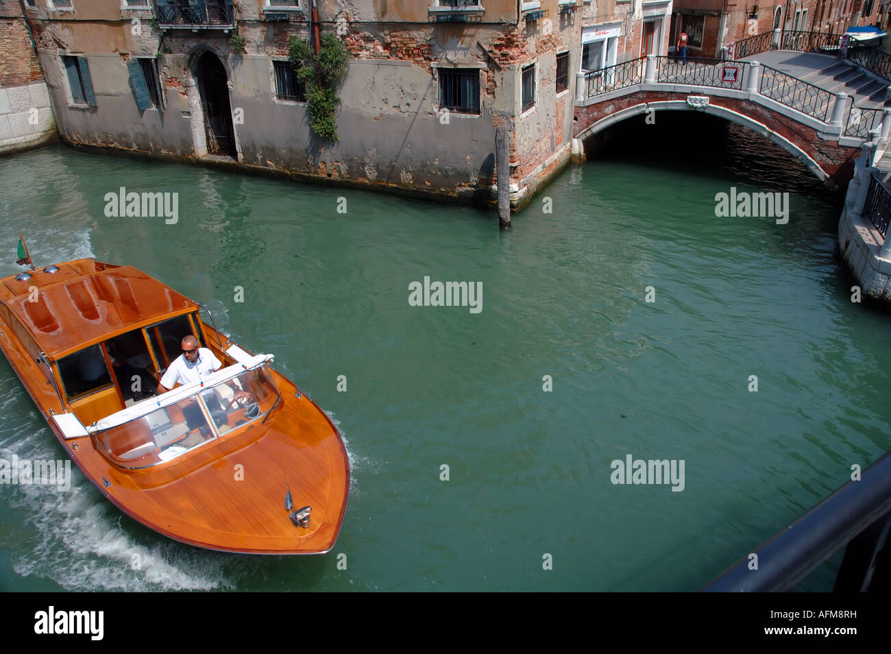 Wooden motorboat zipping through the canals of Venice Italy No PR or MR ...
