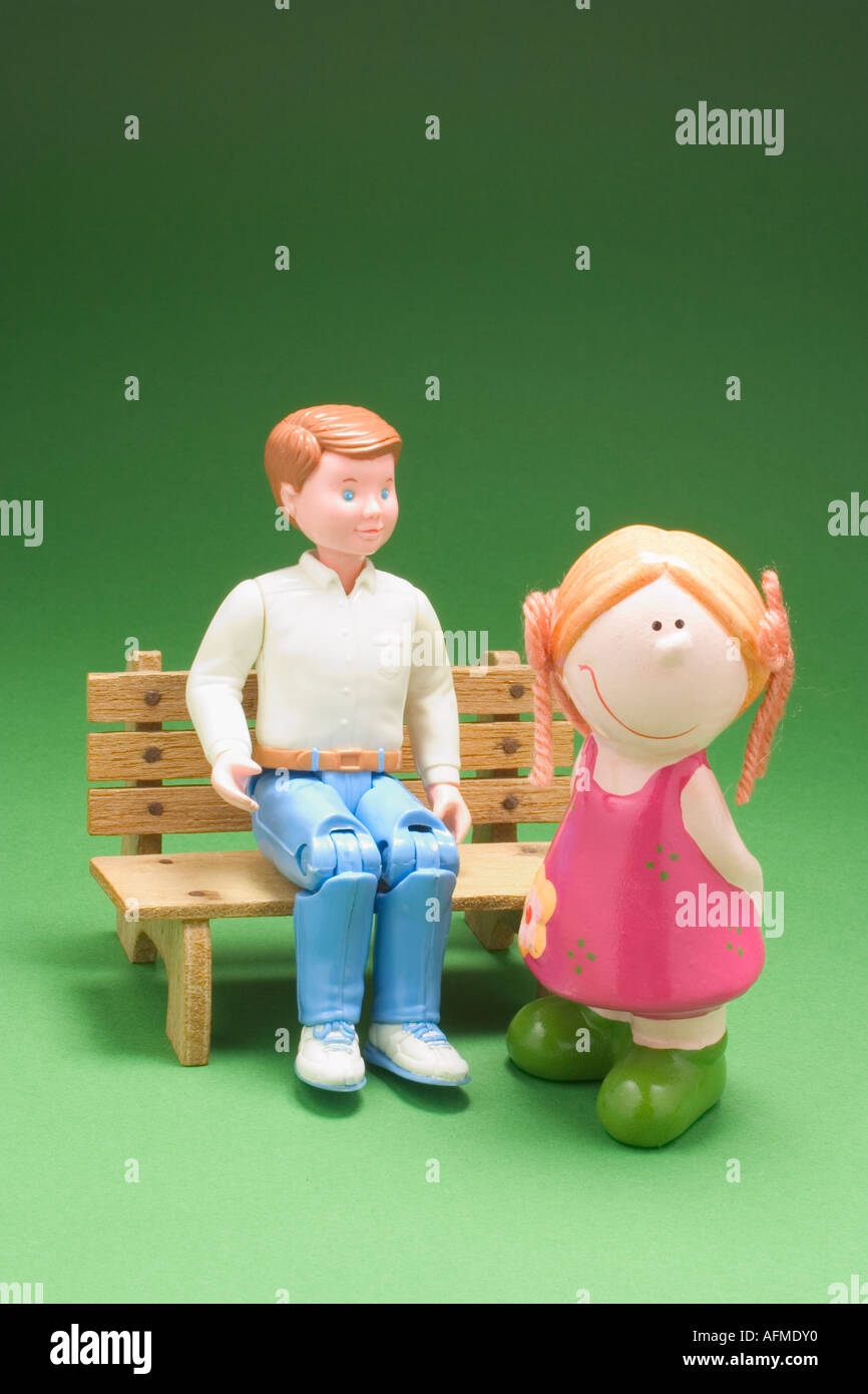 Boy and Girl Figurines on Park Bench Stock Photo - Alamy
