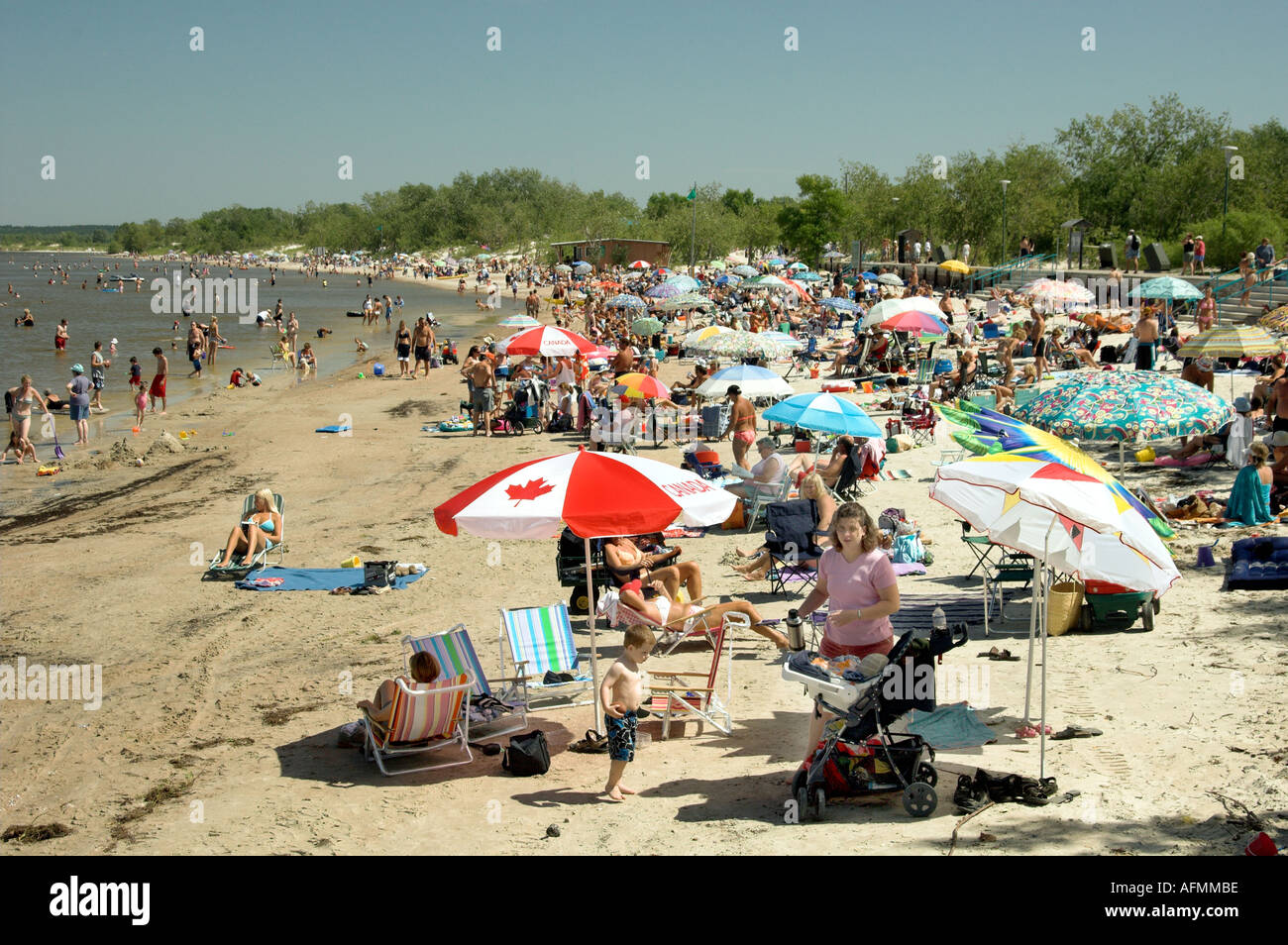 Beach scene with sunbathers and colorful umbrellas at Grand Beach ...