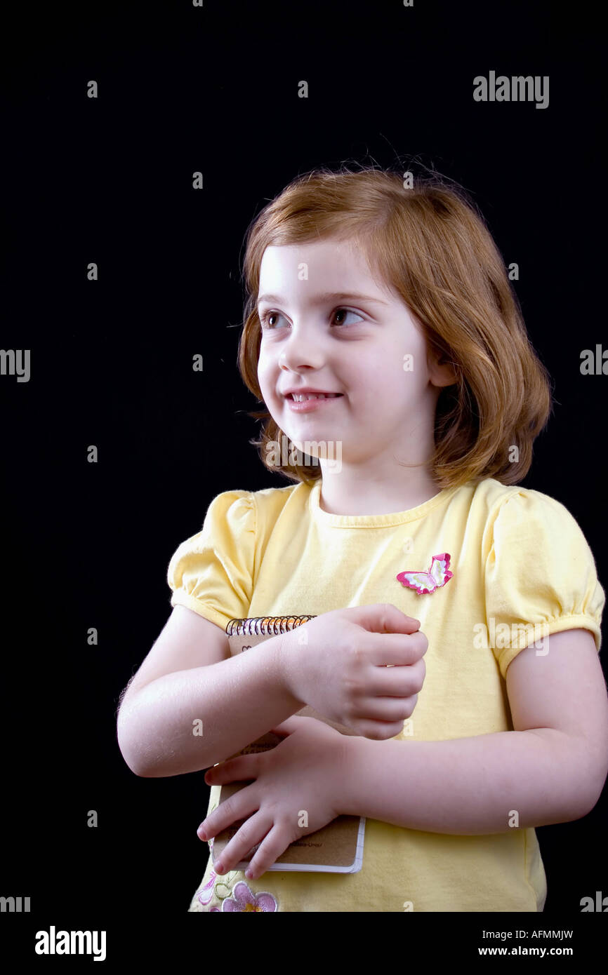 Five year old girl holding a notebook and pencil Stock Photo - Alamy
