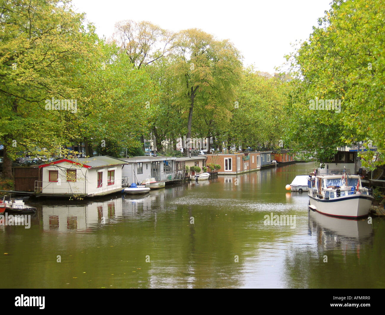 Canal boats in tree lined Amsterdam canal Netherlands Stock Photo - Alamy