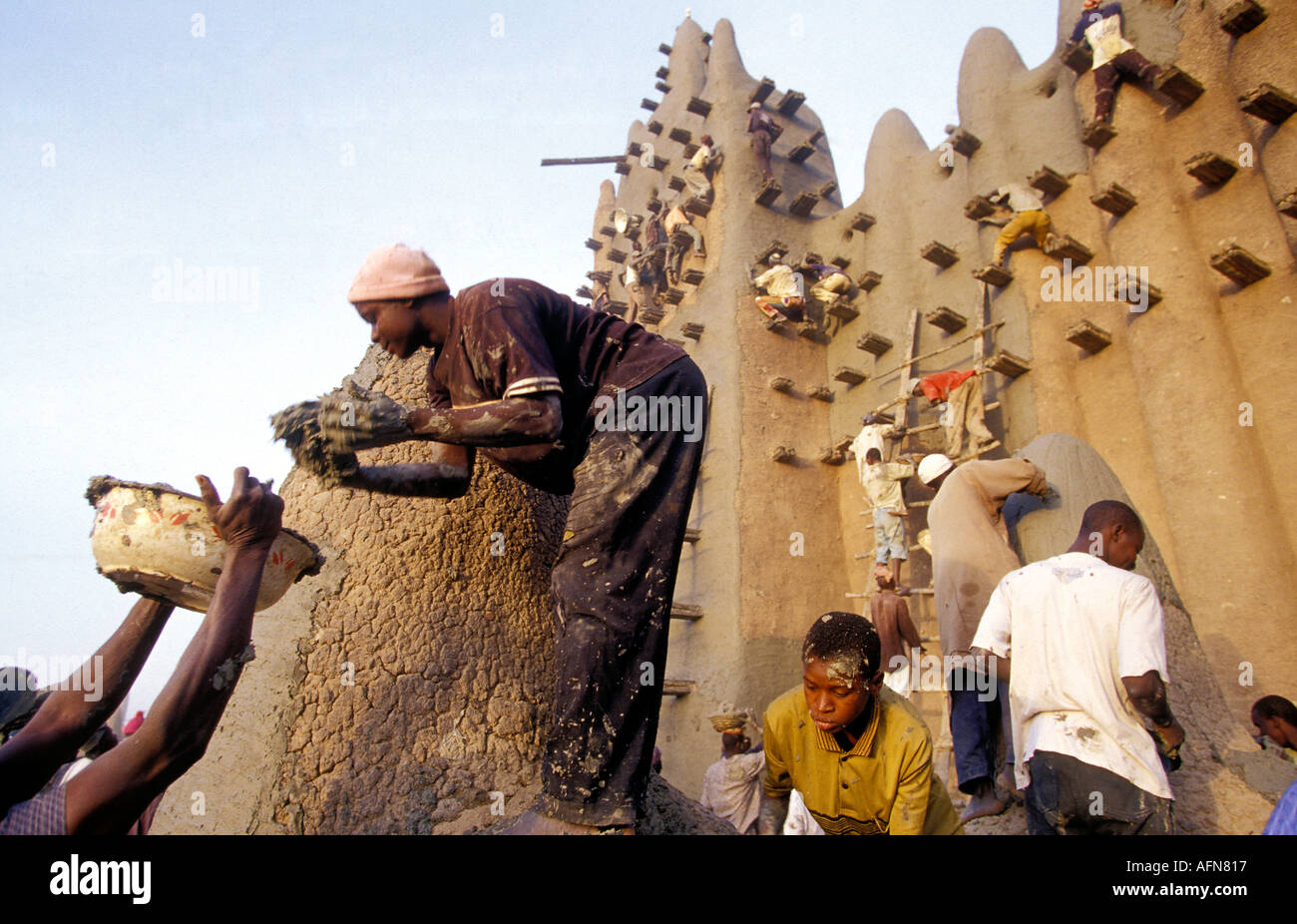 Mali Djenne People working on restoring and applying the Grand Mosque ...