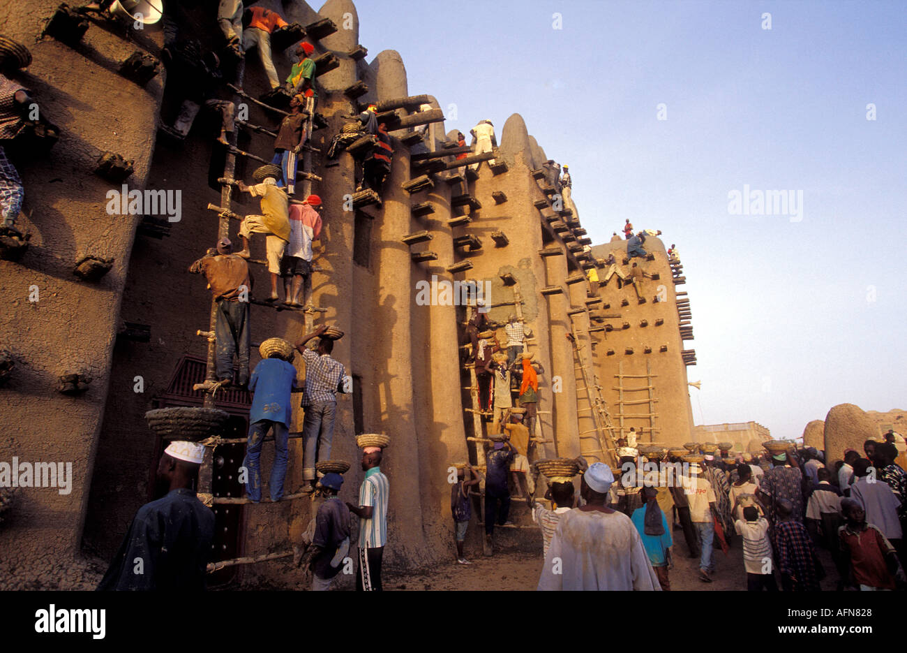 Mali Djenne People working on restoring and applying the Grand Mosque ...