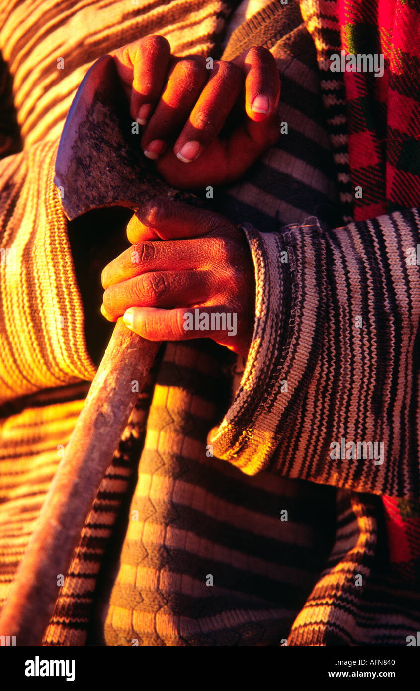 Young boys hand holding a wooden hatchet axe in his hands wearing ...