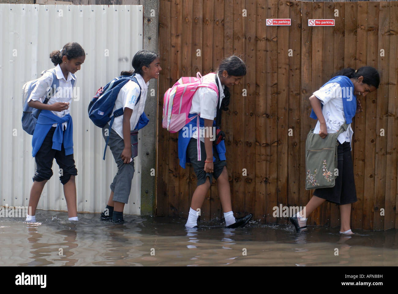 A group of young school girls wading through flood water Stock Photo ...