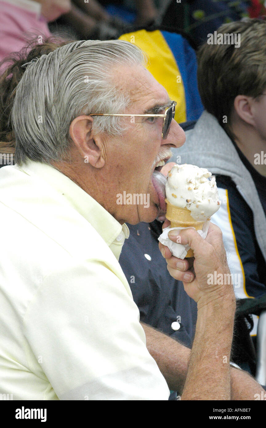 Senior male eats ice cream while he relaxes Stock Photo - Alamy