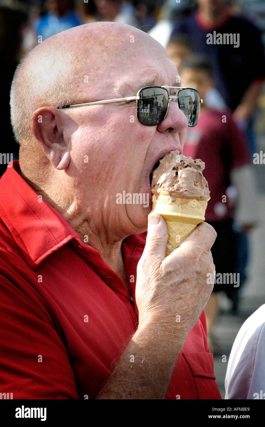 Senior male eats ice cream while he relaxes Stock Photo - Alamy
