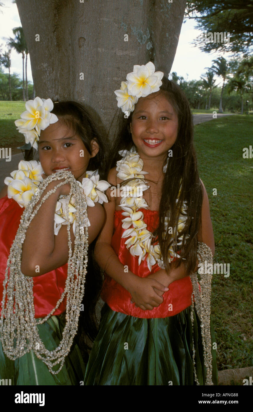 Smiling Hawaiian girls with flowers in their hair greets visitors at ...
