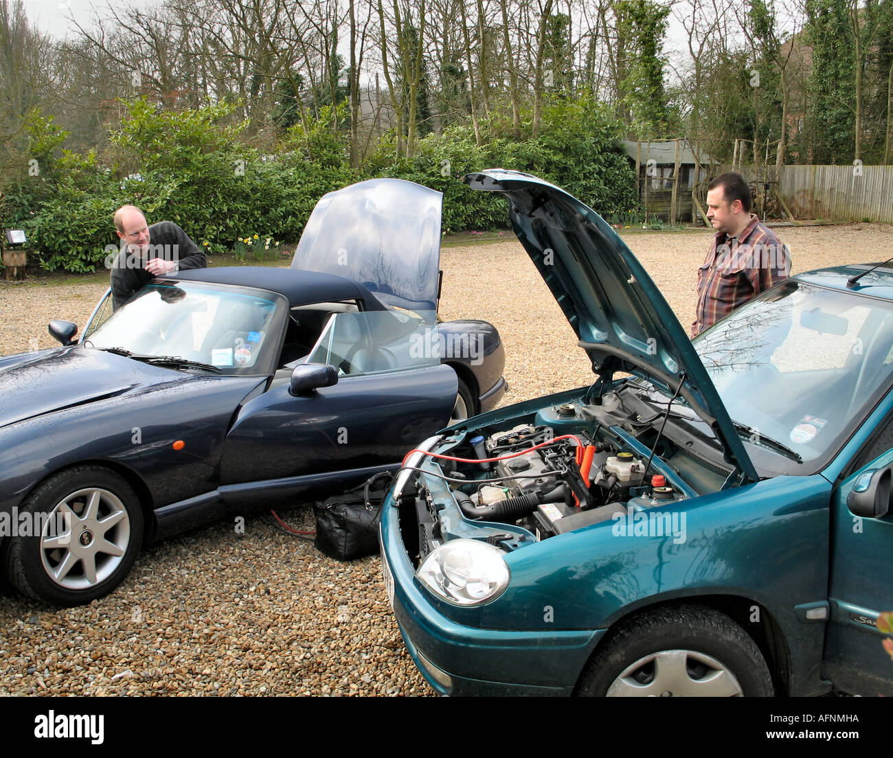 Two men are struggling with a car breakdown, opening the bonnet and ...