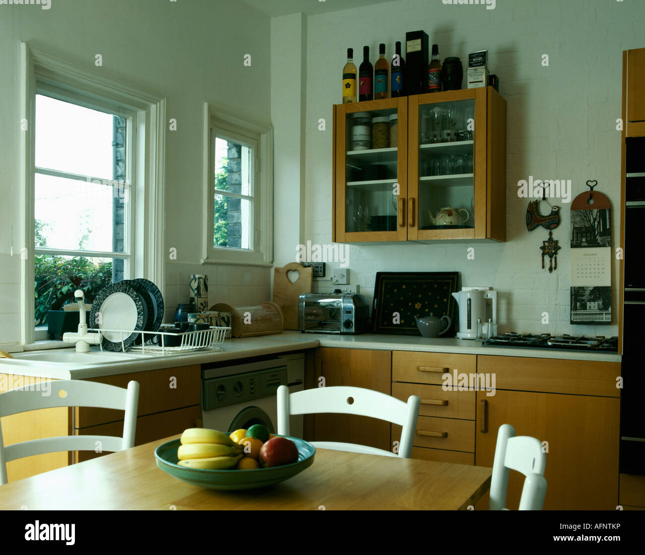 Small pine cupboard above wooden units in kitchen with pine table and ...