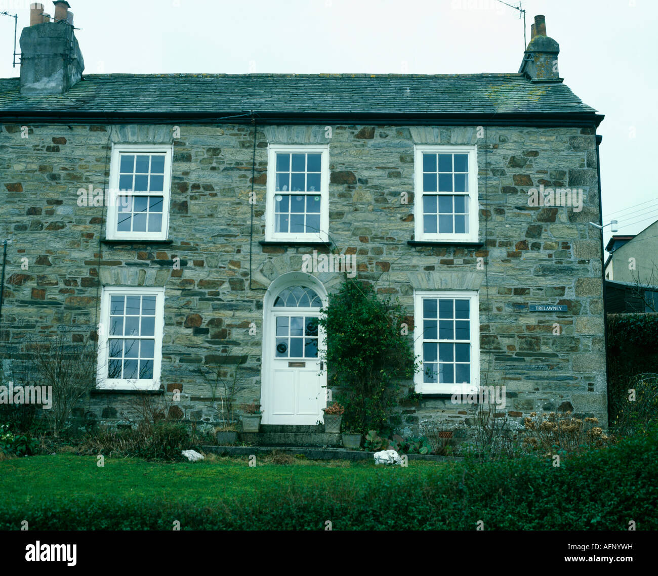 Traditional stone cottage with white windows and door Stock Photo - Alamy