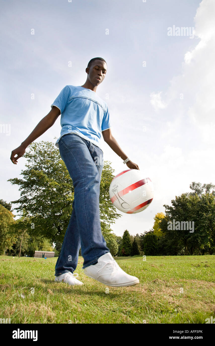 Young Black man playing football in the Park Stock Photo - Alamy